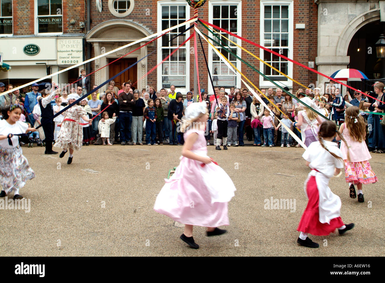 School children perform a Maypole dance routine dressed in traditional ...
