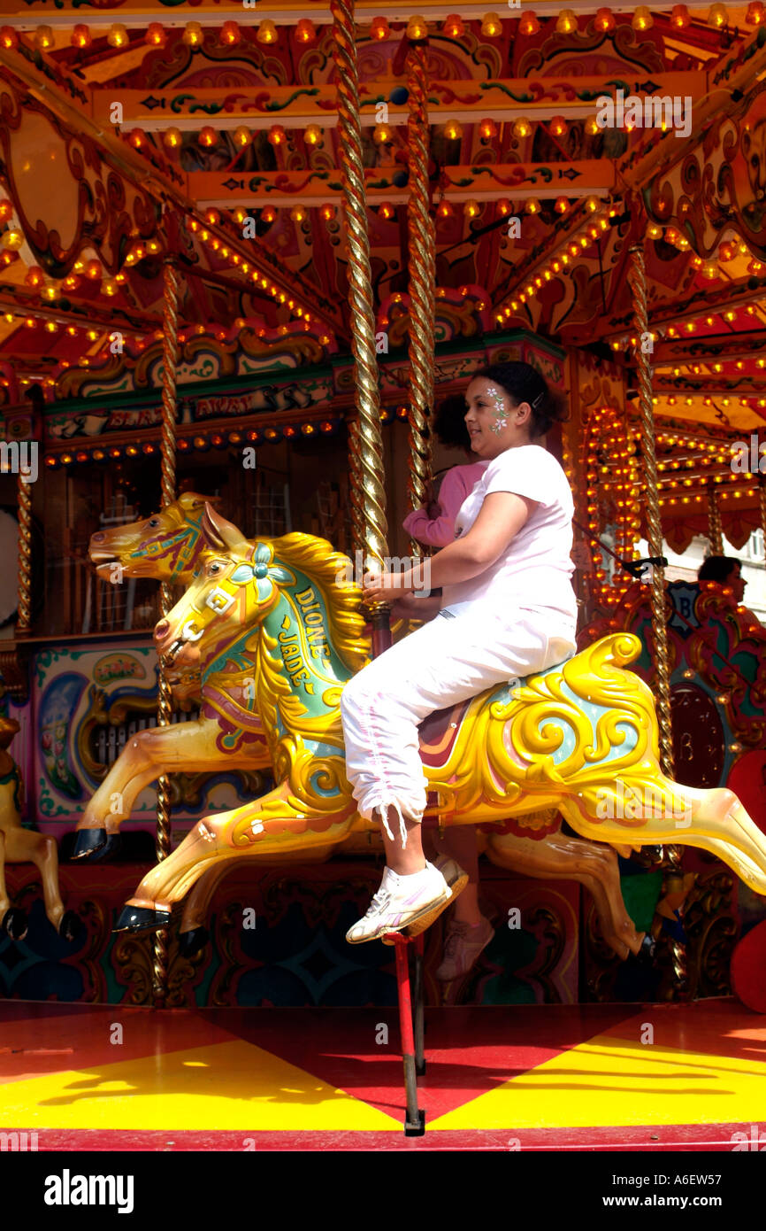 Young female having fun riding a horse on a carousel Stock Photo - Alamy