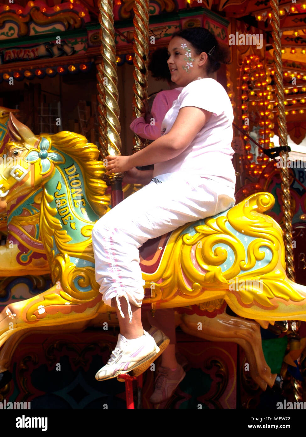 Young female having fun riding a horse on a carousel Stock Photo - Alamy
