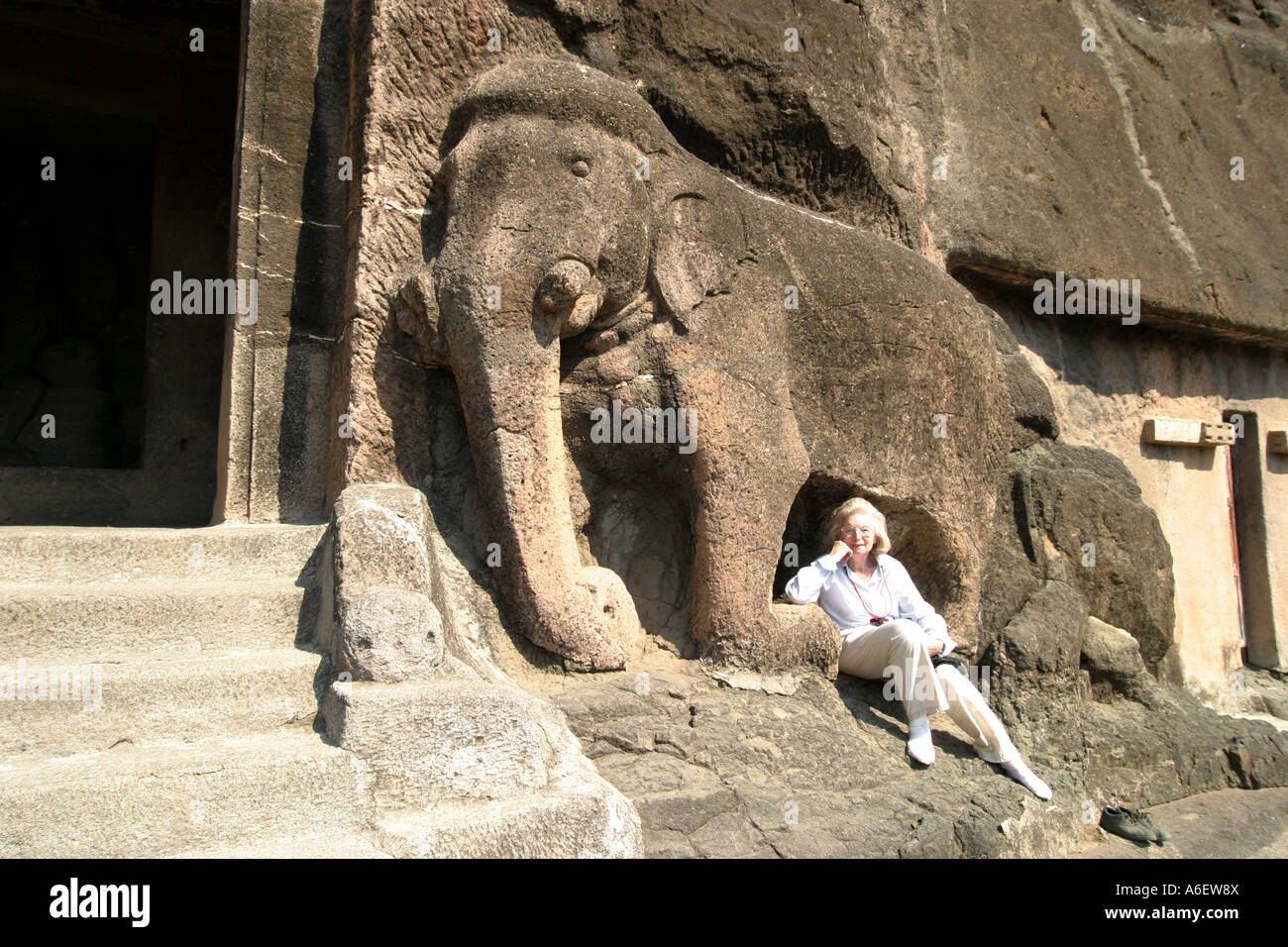 Tourist visiting the Ajanta caves resting at the feet of a large ...