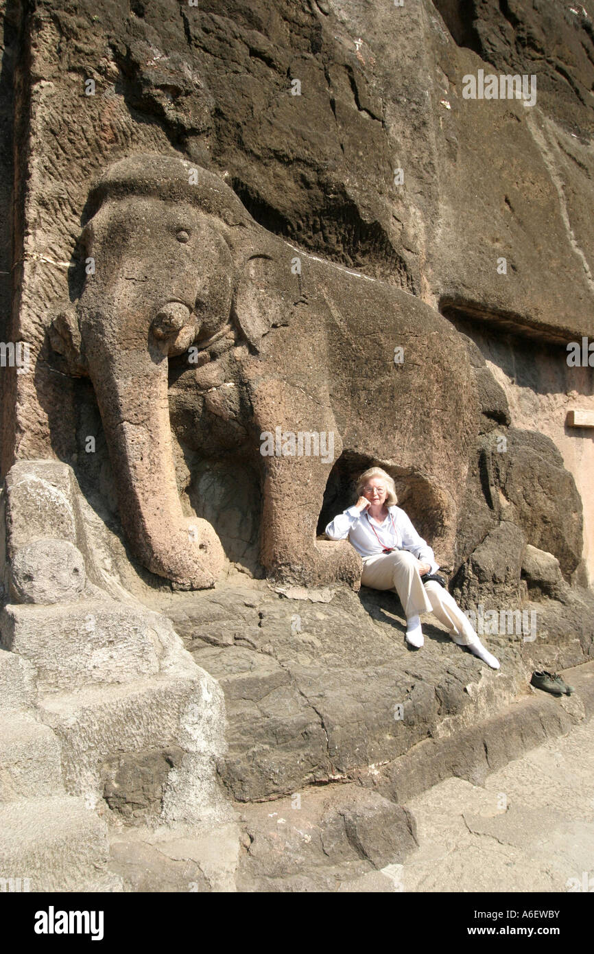 Tourist visiting the Ajanta caves resting at the feet of a large ...