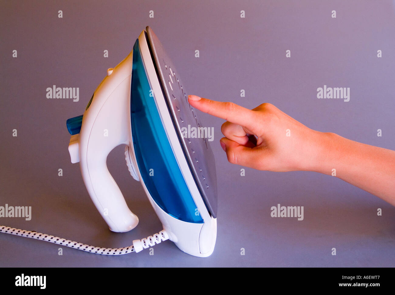 Testing whether the steam iron is hot Stock Photo - Alamy