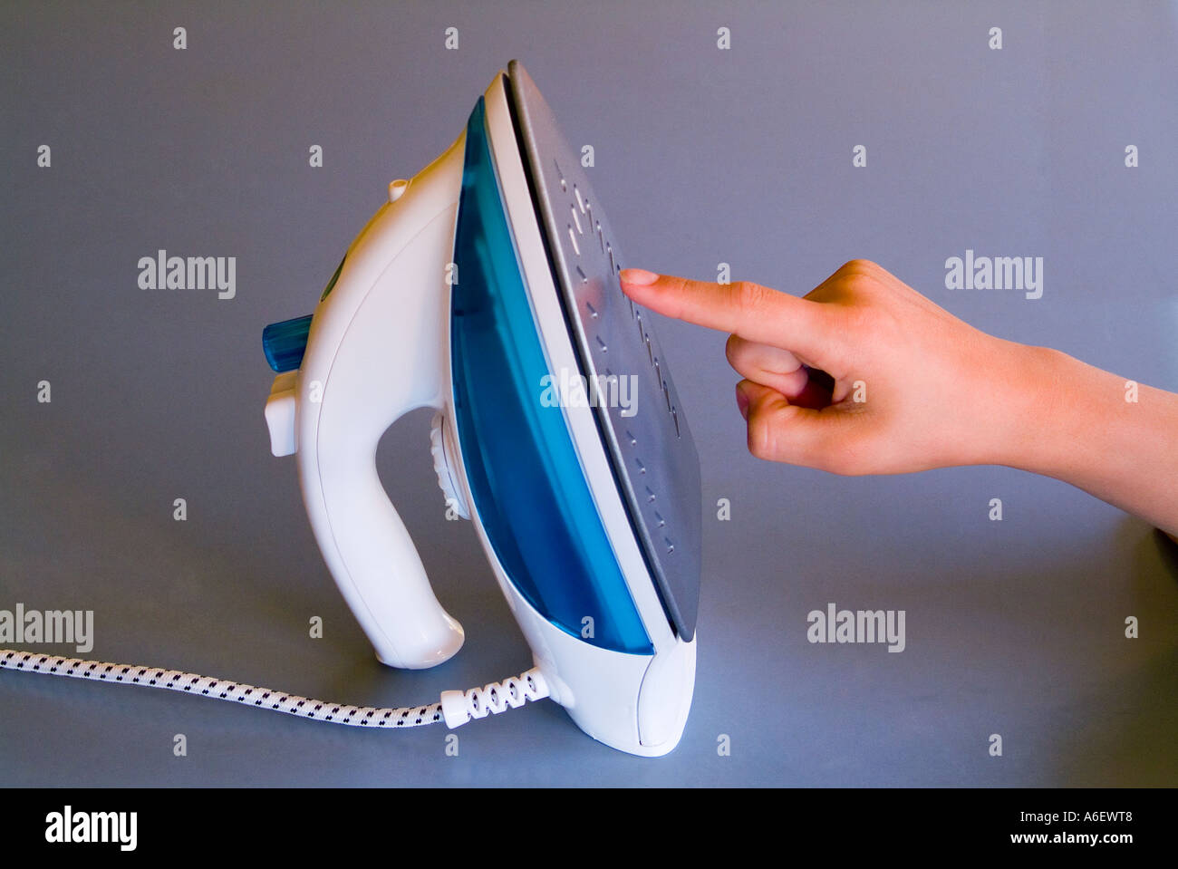 Testing whether the steam iron is hot Stock Photo - Alamy