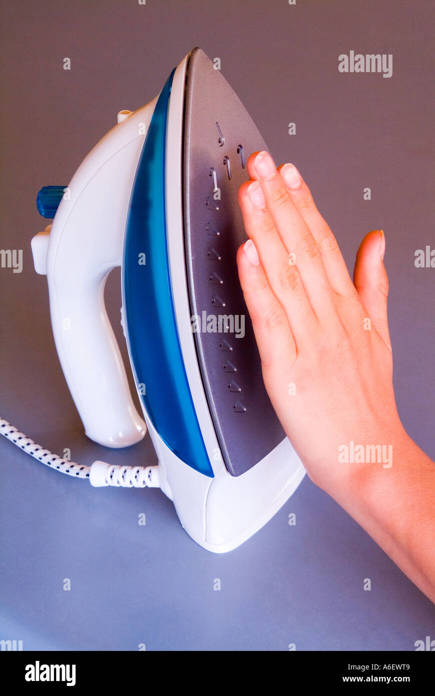 Testing whether the steam iron is hot Stock Photo - Alamy