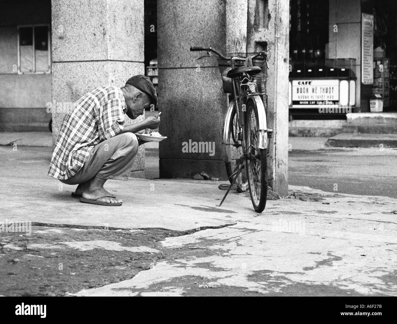 Man eating rice in downtown Saigon Stock Photo - Alamy