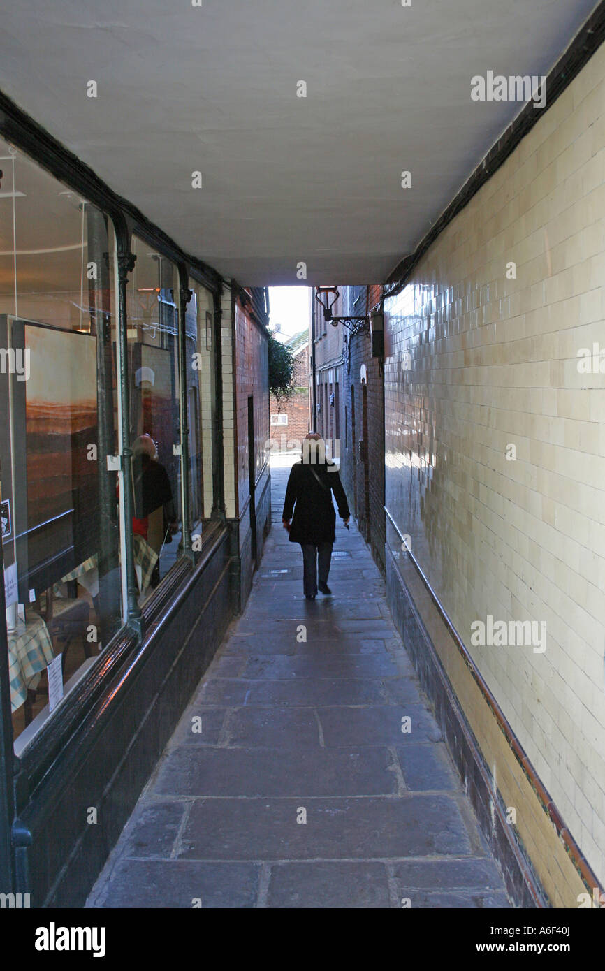 FEMALE WALKING THROUGH A DARK PEDESTRIAN ALLEY WAY. HIGH STREET. OLD ...