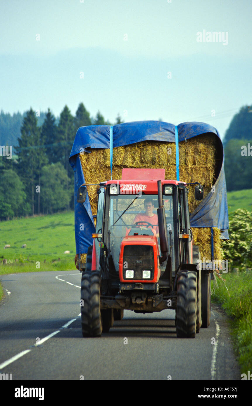 SCOTLAND The Trossachs Young man drive tractor pulling wagon loaded ...