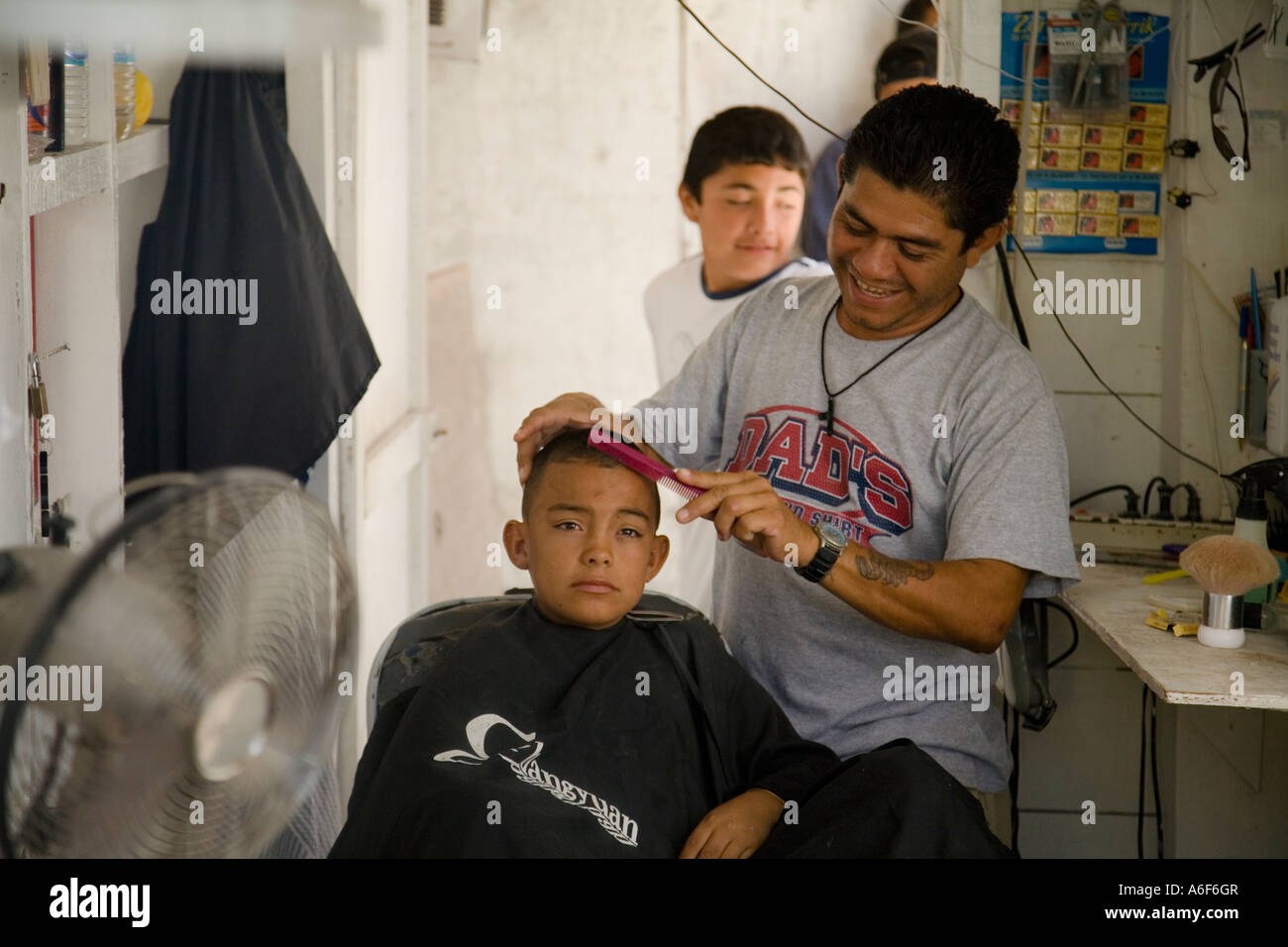 BELIZE Ambergris Caye Man cut male child s hair in small barber shop ...