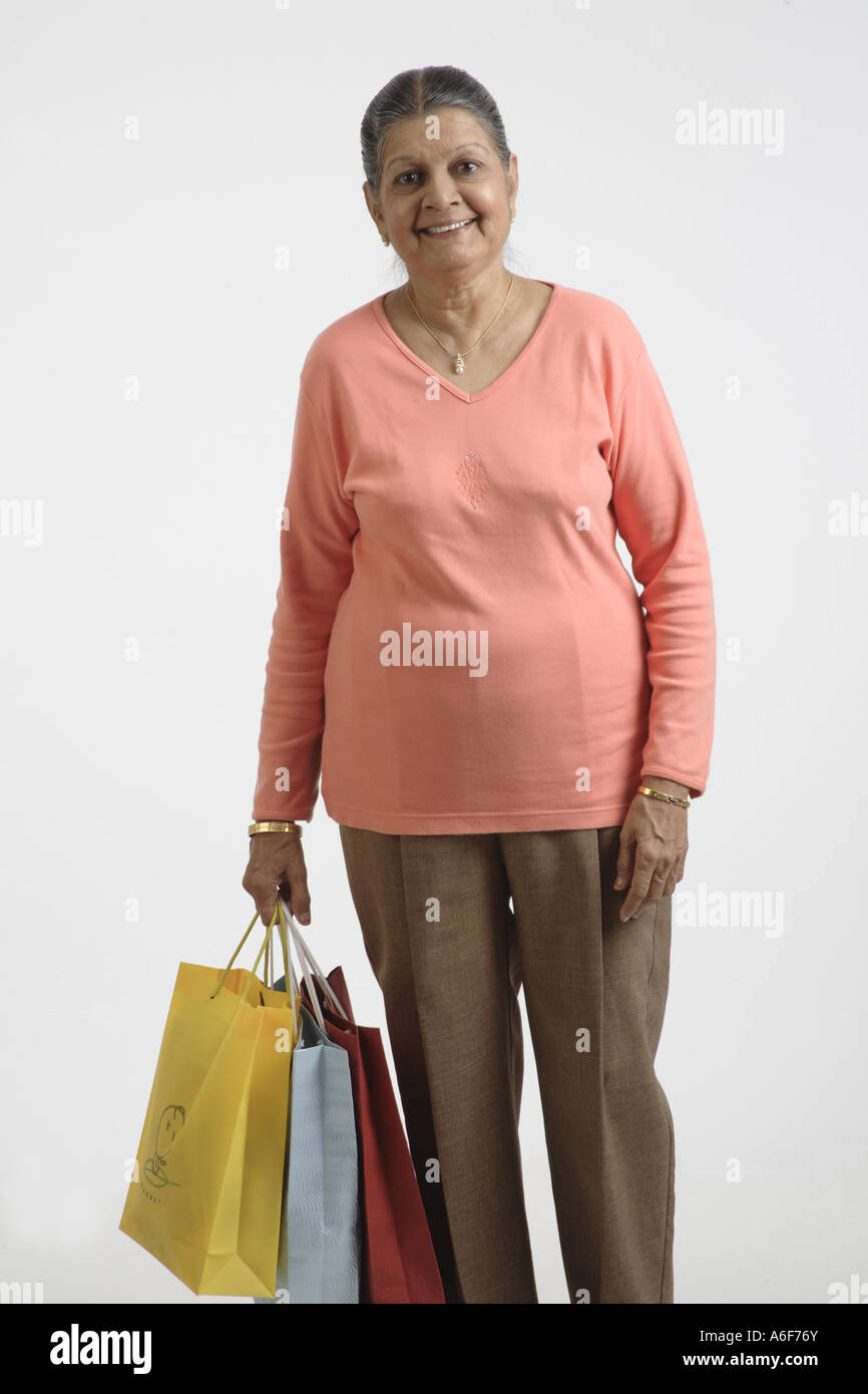 Old lady holding colourful shopping bags in her hand Stock Photo - Alamy
