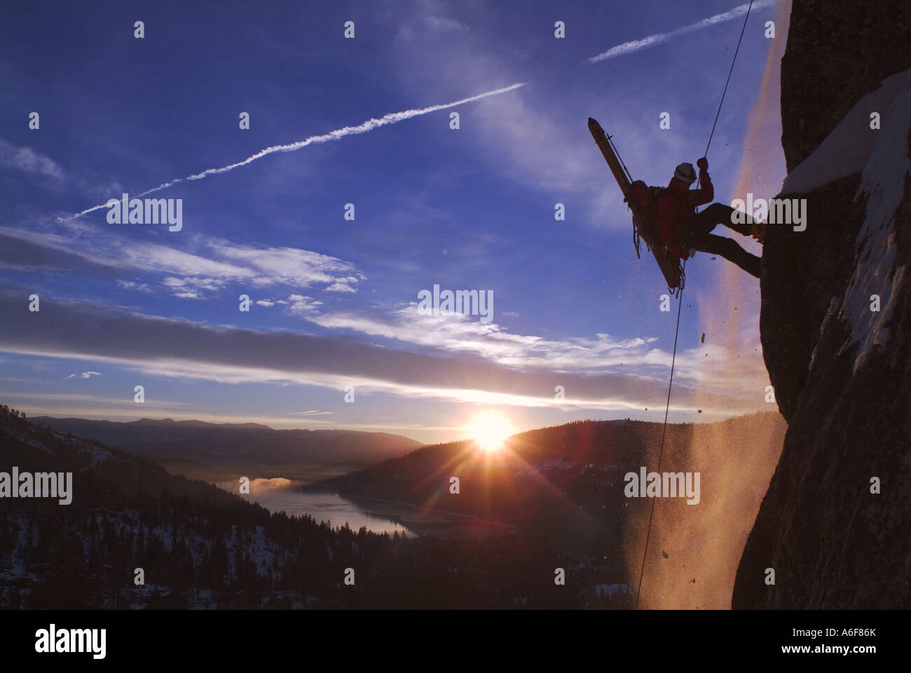 Man rappelling during small avalanche with skis on his back on Donner ...