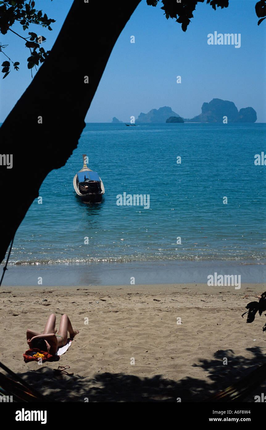 Woman in bikini looking at Tonsai Beach with longail boat, blue sky ...