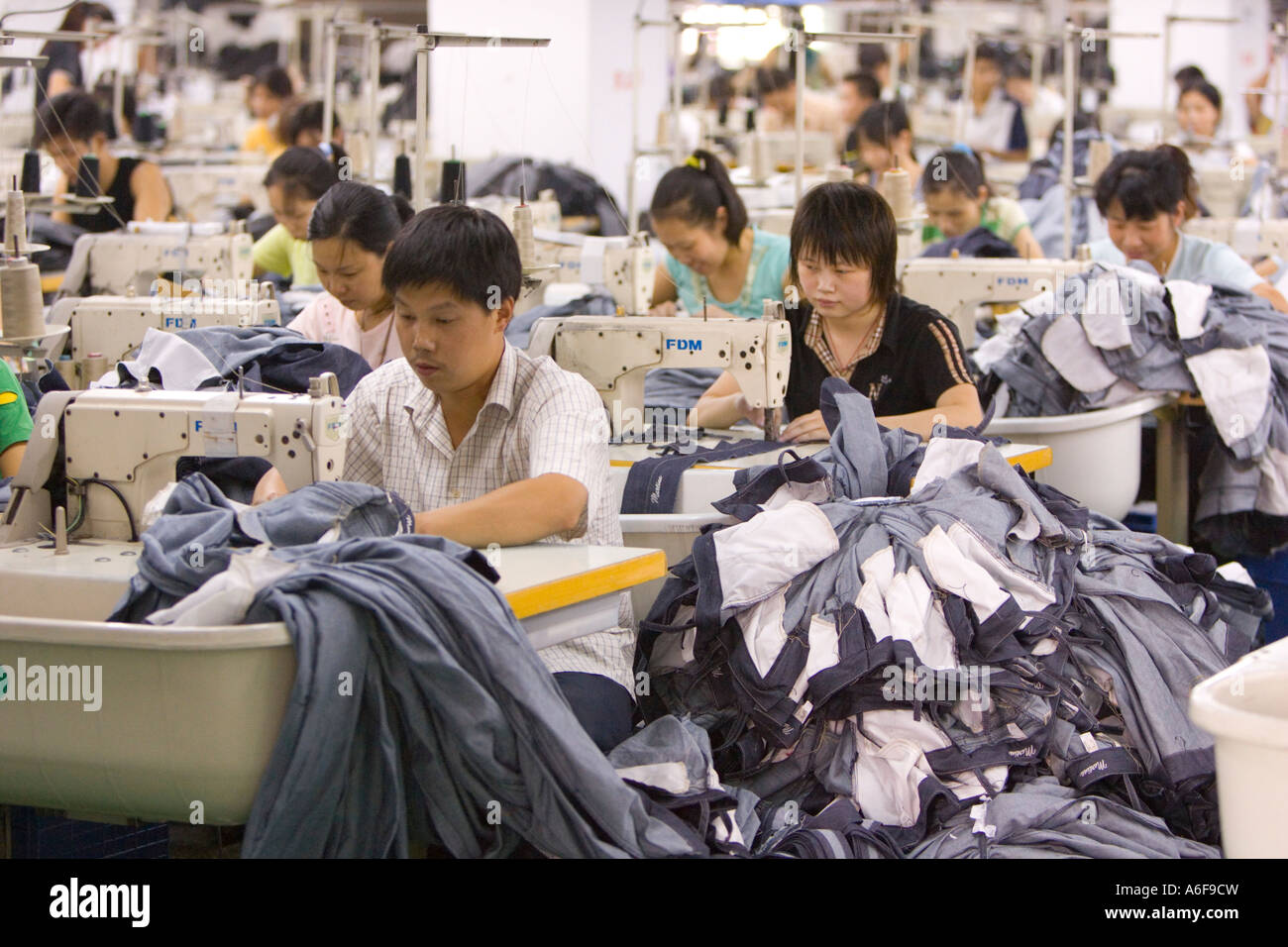 SHENZHEN GUANGDONG PROVINCE CHINA Workers sewing Mango jeans in garment factory in city of ...