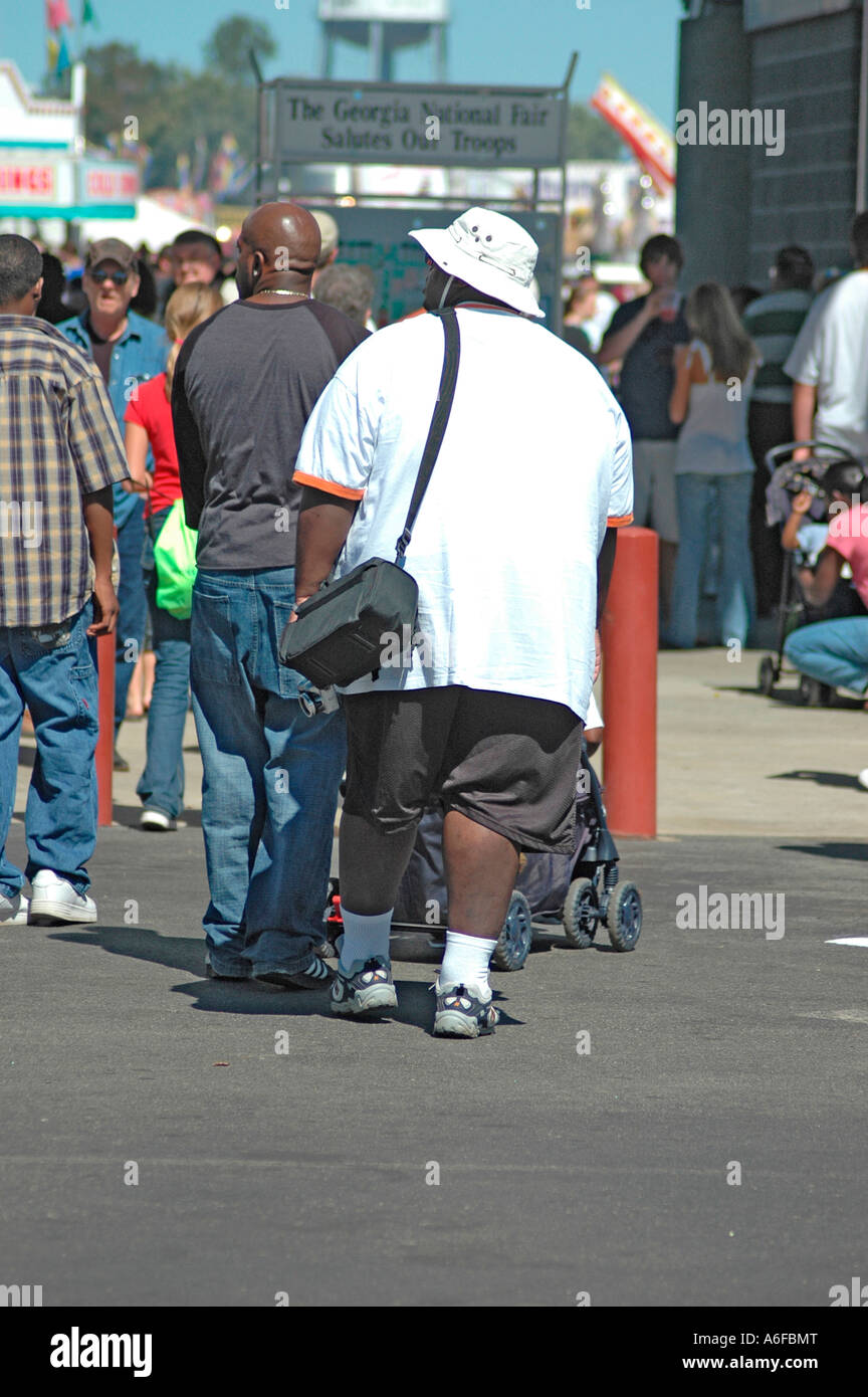 Very large heavy people at Fair in Georgia man with camera bag and hat ...