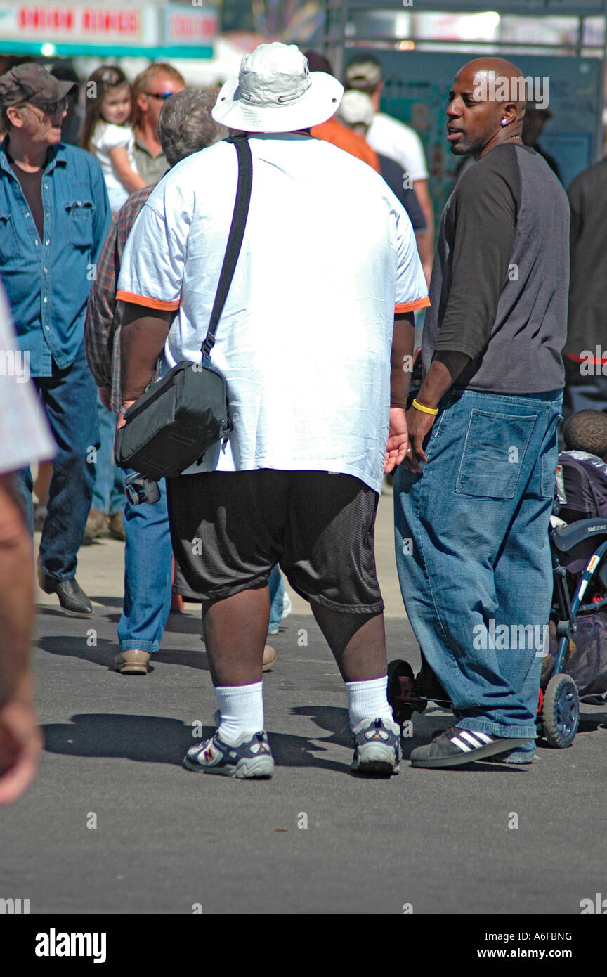 Very large heavy people at Fair in Georgia man with camera bag and hat ...