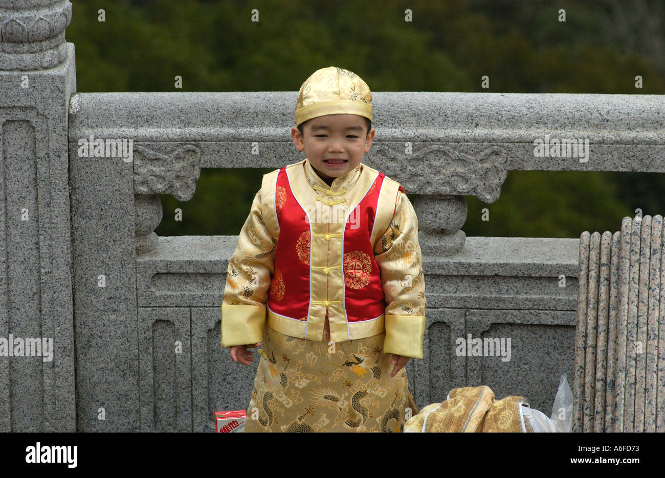 Child in traditional chinese dress at the site of bronze statue of the ...