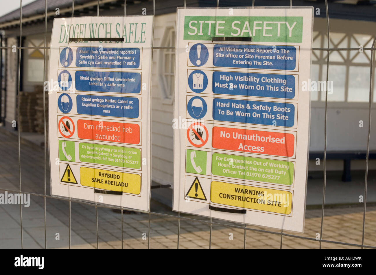 Construction building site safety warning sign on fence in welsh and ...