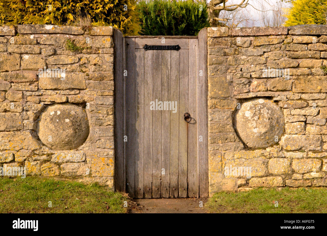 Wooden gate in garden wall made of Cotswold stone at Snowshill ...