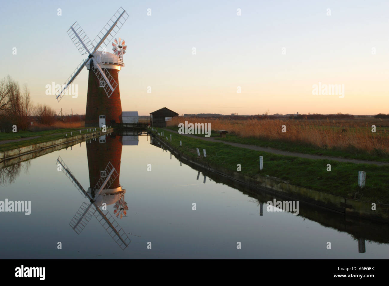 Windmill in the evening light with full reflection in a canal in ...