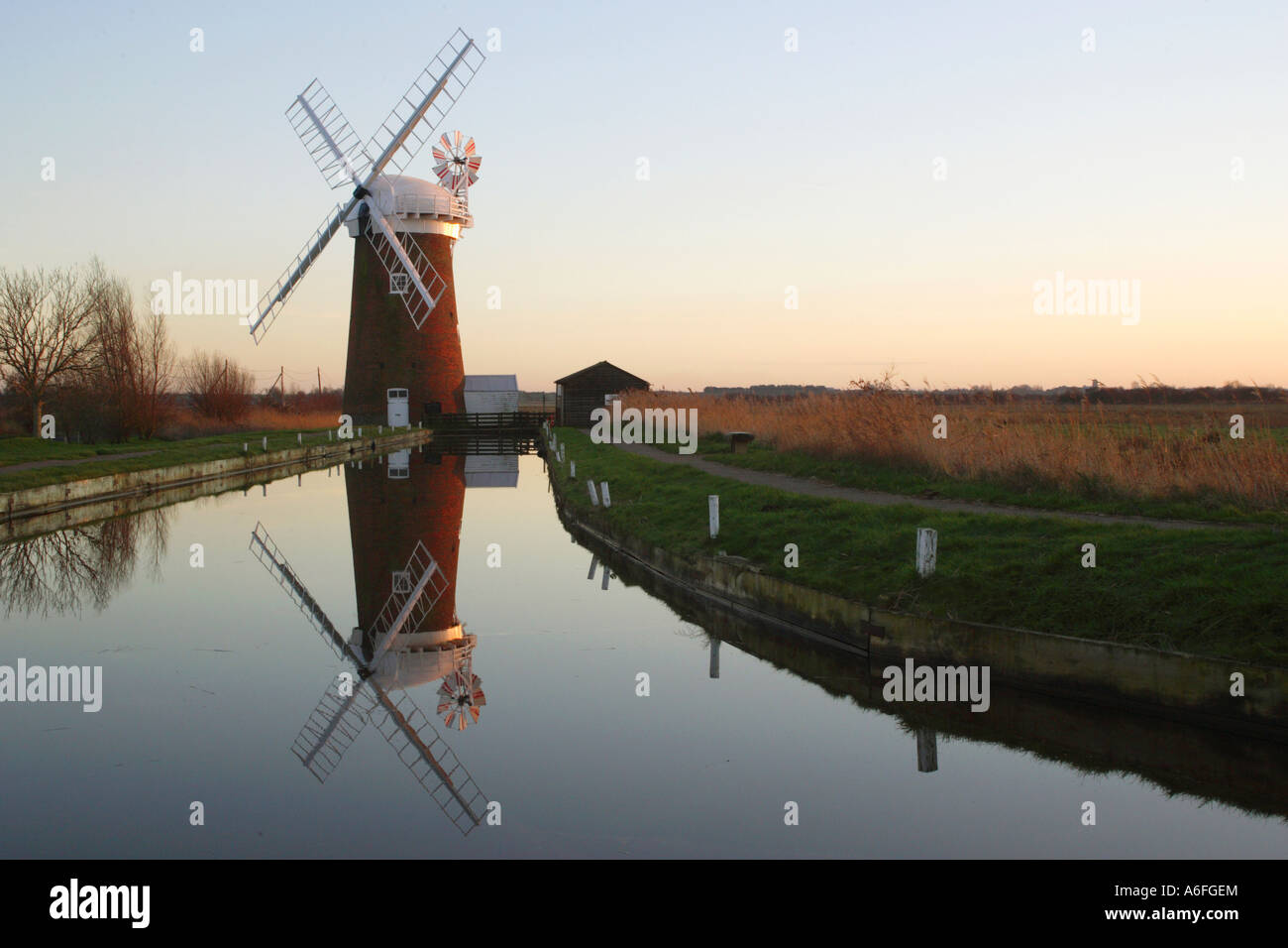 Windmill in the evening light with full reflection in a canal in ...