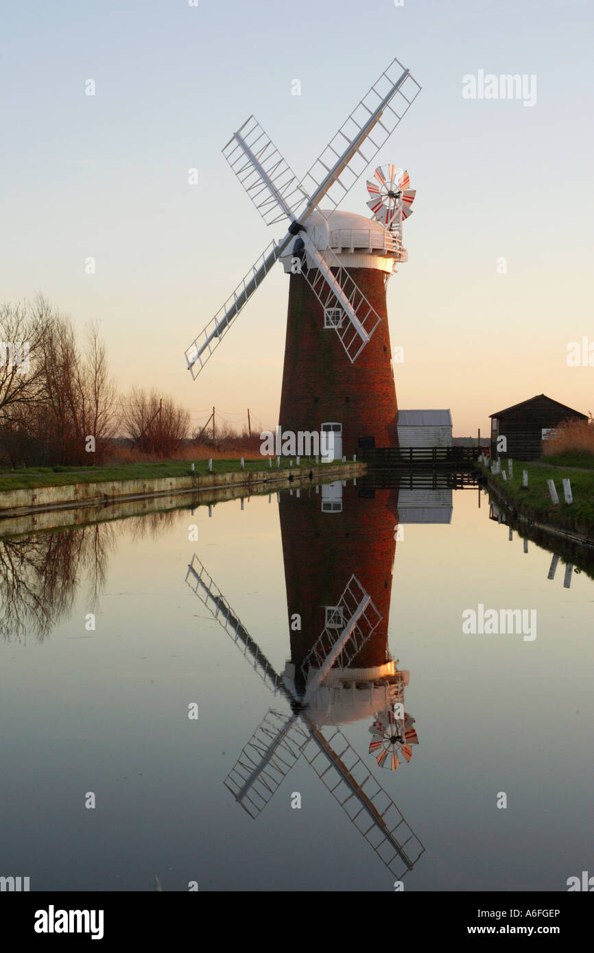 Windmill in the evening light with full reflection in a canal in ...
