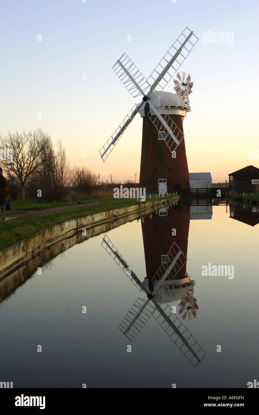 Windmill in the evening light with full reflection in a canal in ...