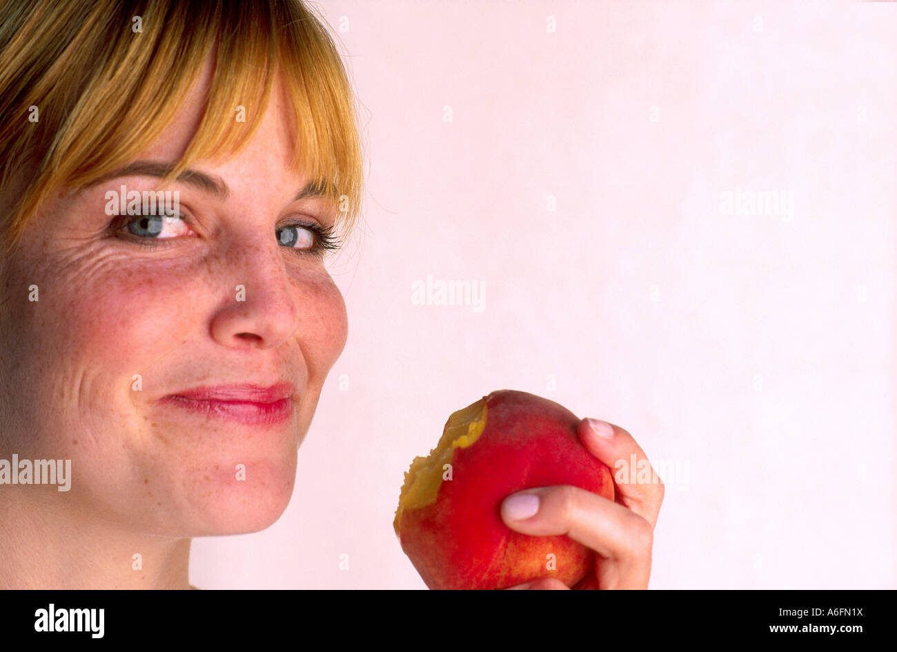 Woman enjoying a juicy red apple Stock Photo - Alamy