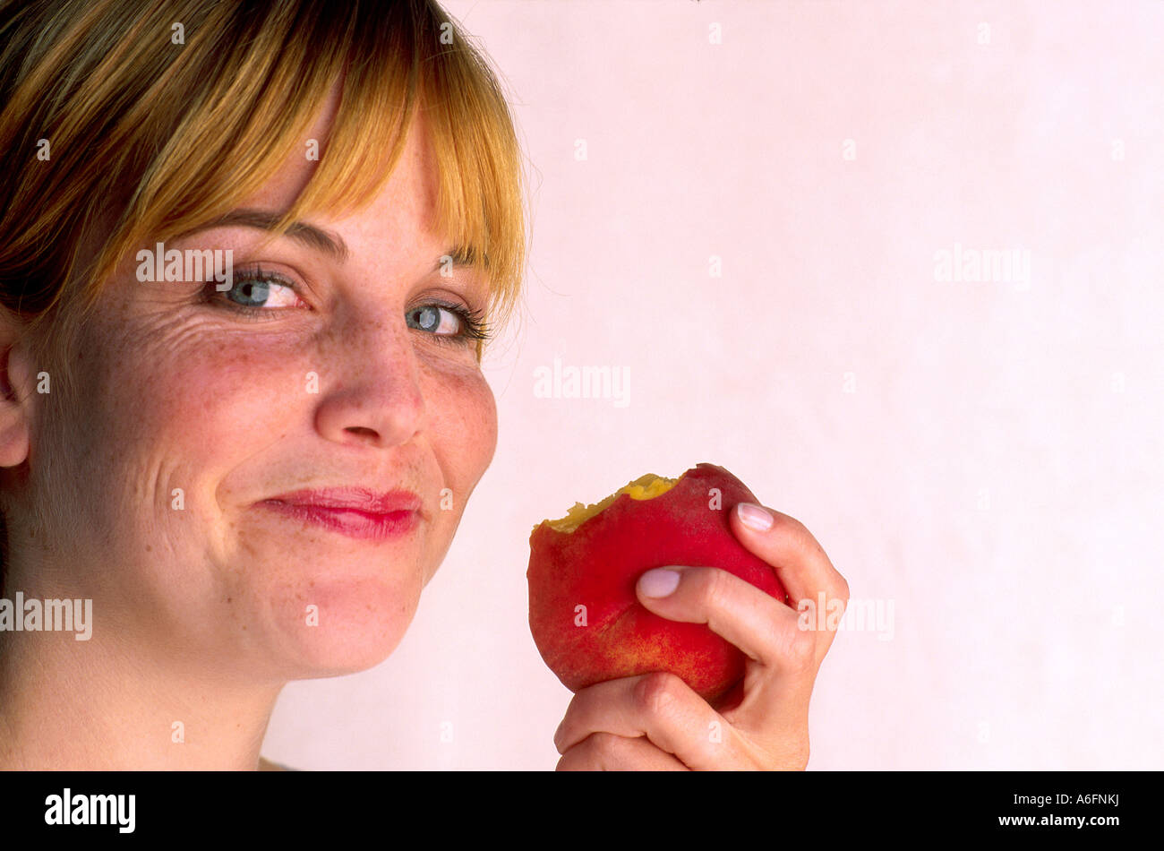 Woman enjoying a juicy red apple Stock Photo - Alamy