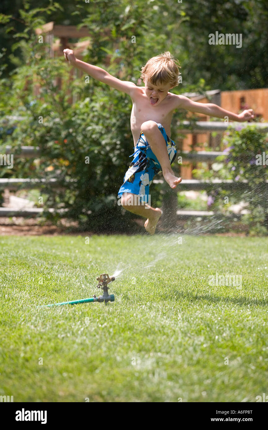 Child Running Through the Sprinklers Stock Photo - Alamy