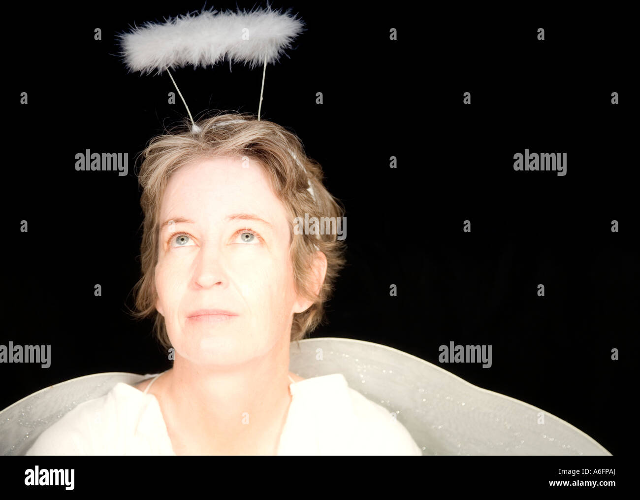 Woman dressed as an angel looking up Stock Photo - Alamy