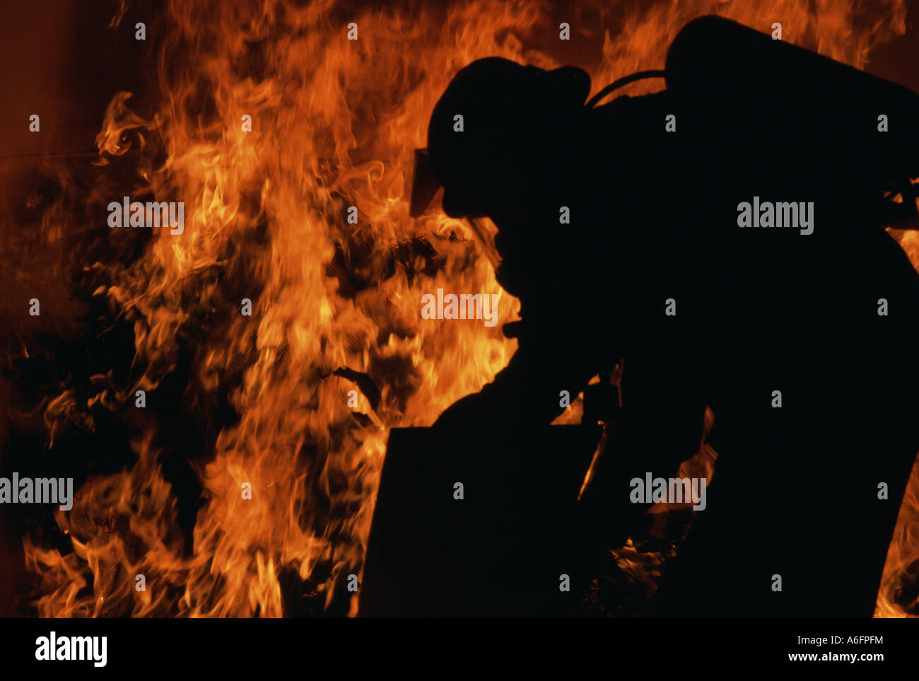 Silhouette of a firefighter with flames blazing around him Stock Photo ...