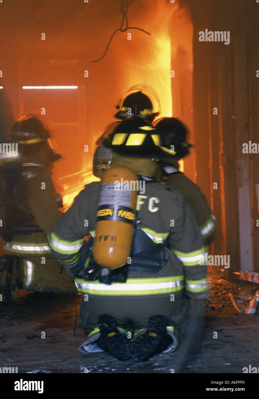 Firefighters going into action into a blazing building Stock Photo - Alamy