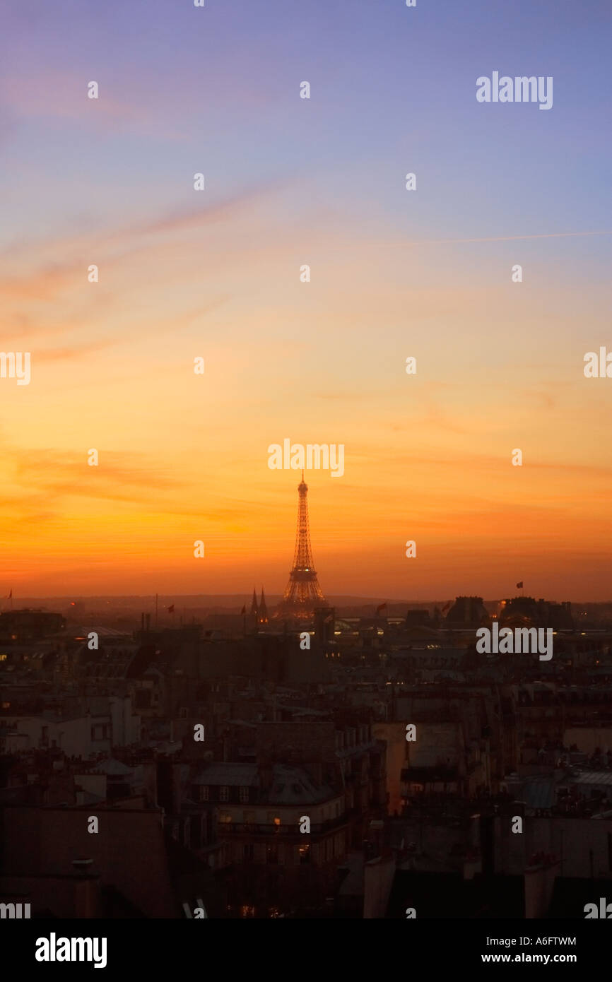 a vertical cityscape of Paris, France shows the Eiffel Tower at sunset ...