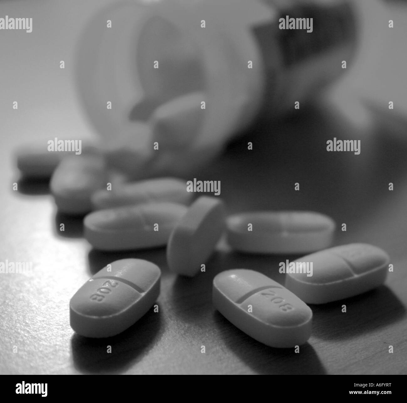 pills spilling from bottle onto wood background red backlight Stock ...