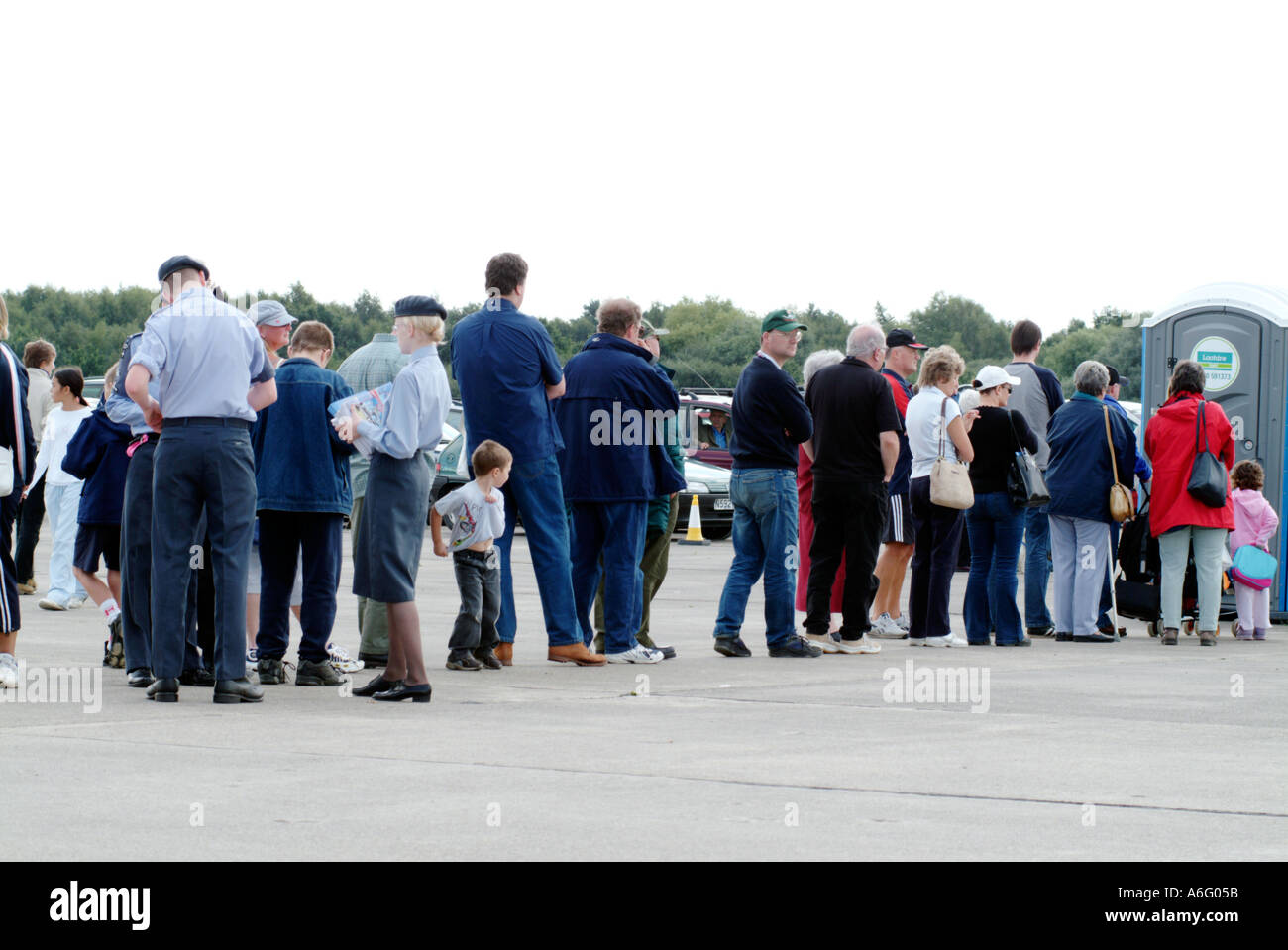 people queing for a toilet a out door event facilties management que ...