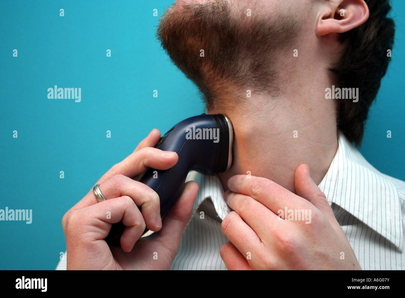 Man using electric shaver blue background Stock Photo - Alamy