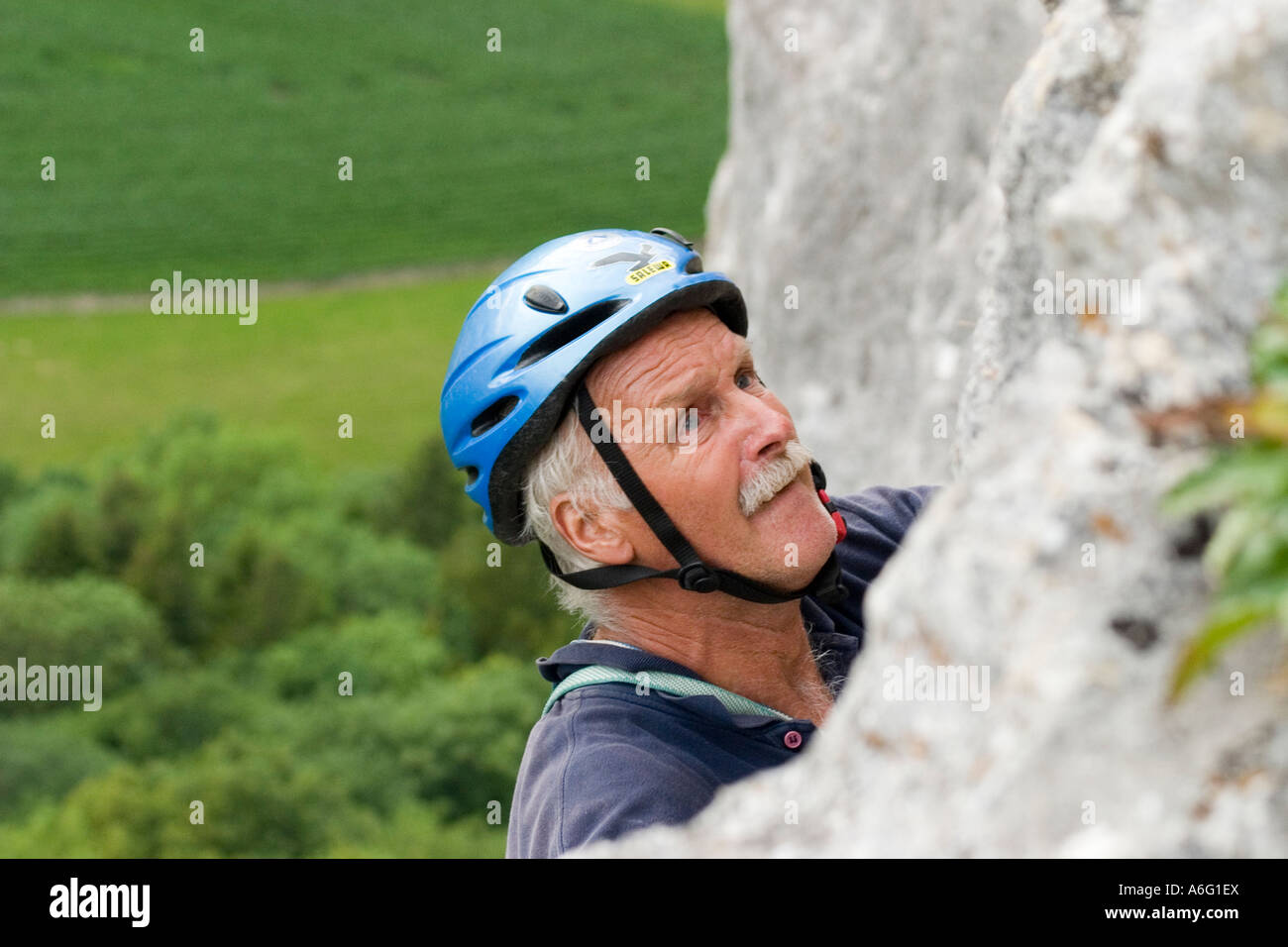 senior man rock climbing in limestone with blue helmet Danube valley ...