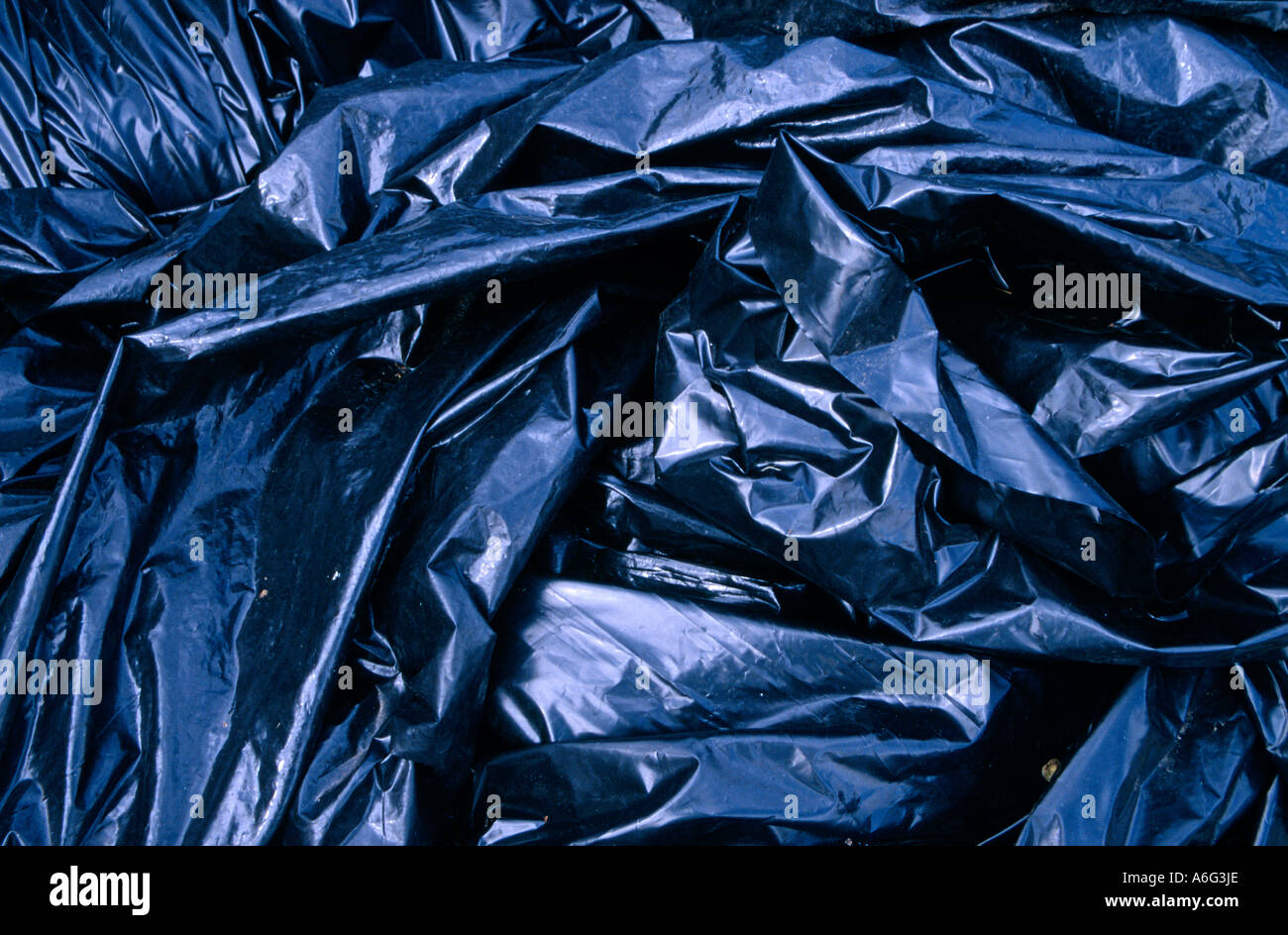 Abstract natural outdoors background image of black wrinkled polythene ...