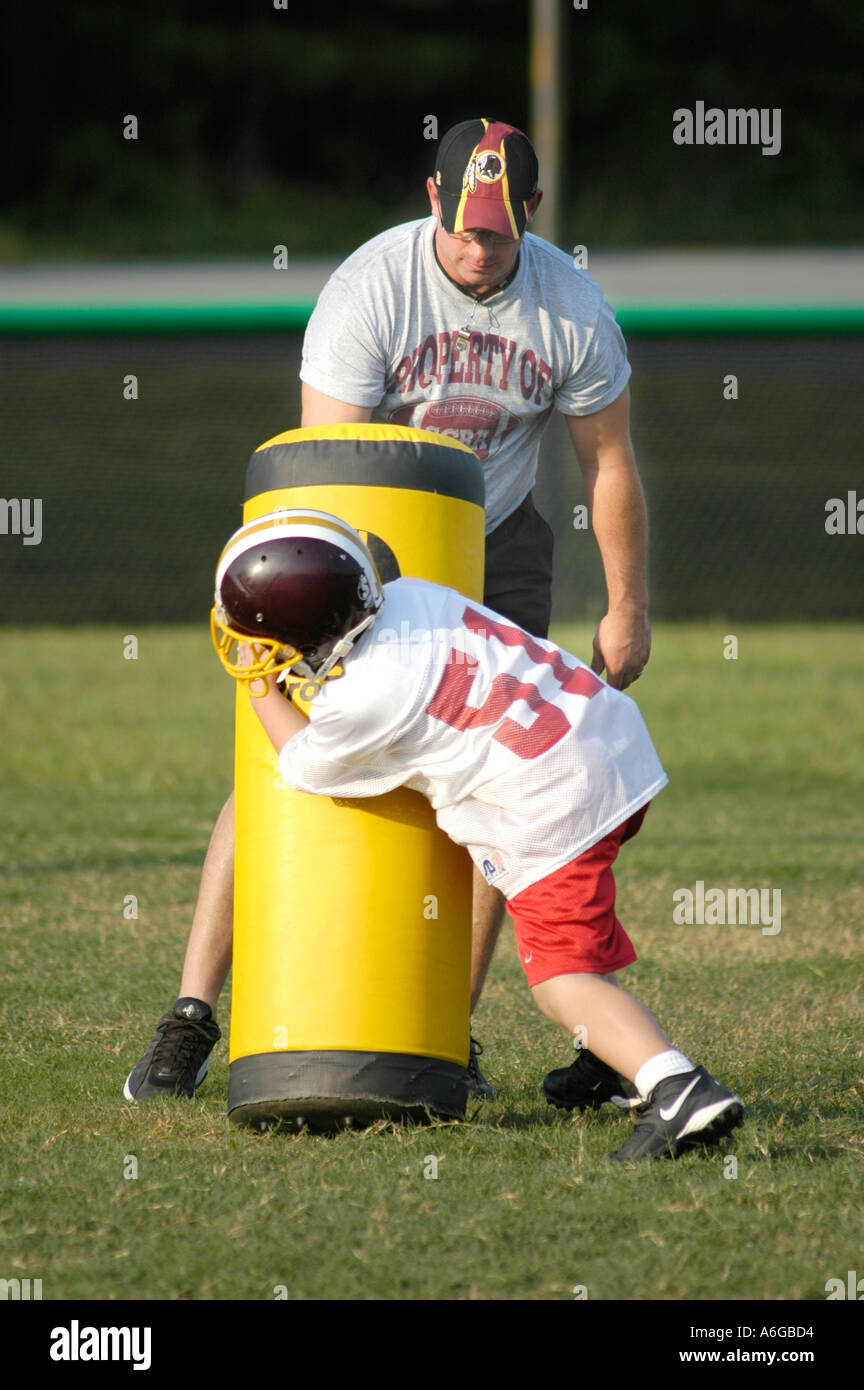 Football coach and Player at Practice learning to block with helmet and ...