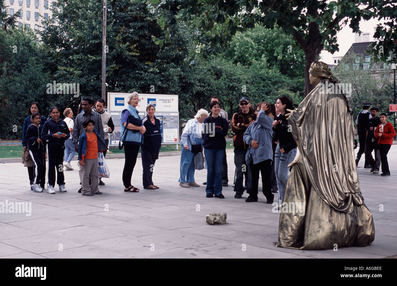 Tourists looking at a human statue street entertainer on the Southbank ...
