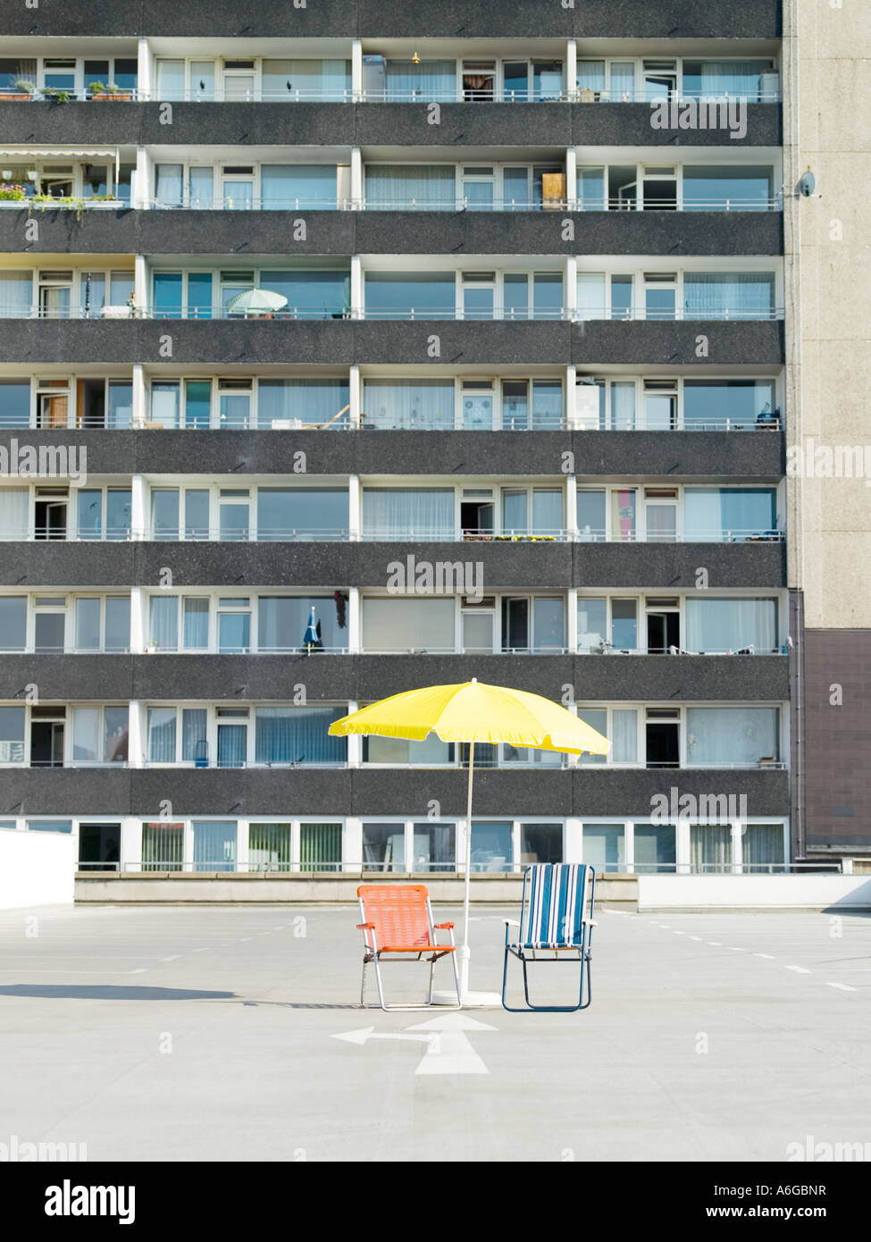 Deckchairs and parasol outside apartment building Stock Photo - Alamy