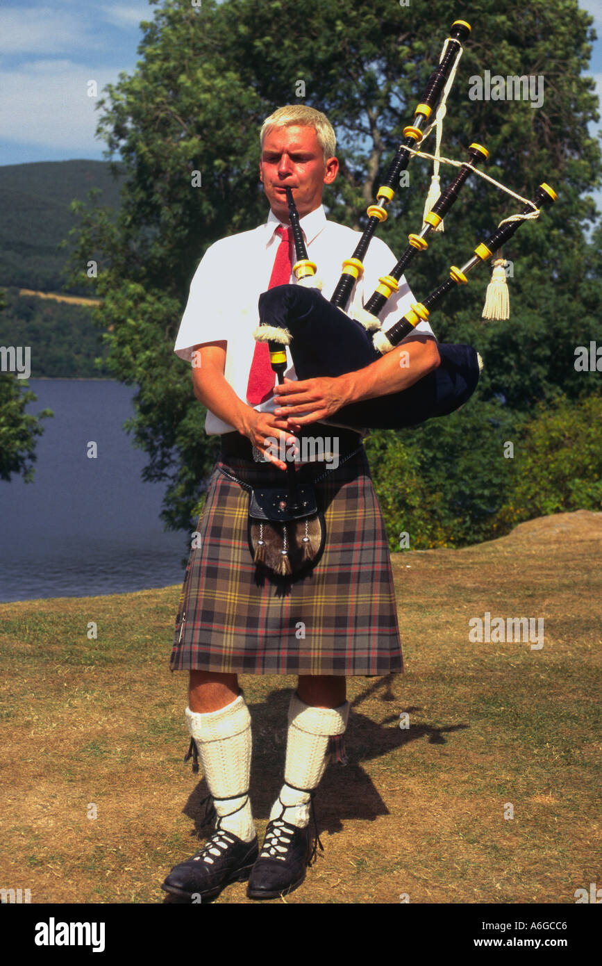 Scotland Loch Ness typical pipe player in scotish dress with lake in ...