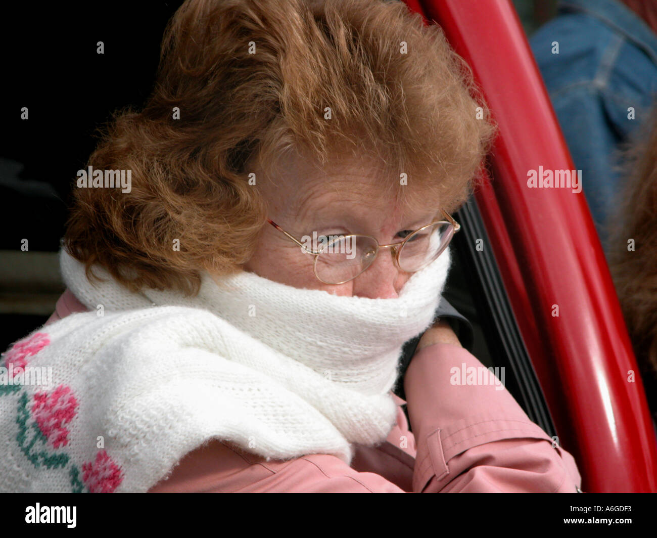 Woman at outdoor event wrapped in scarf due to cold and high winds in ...