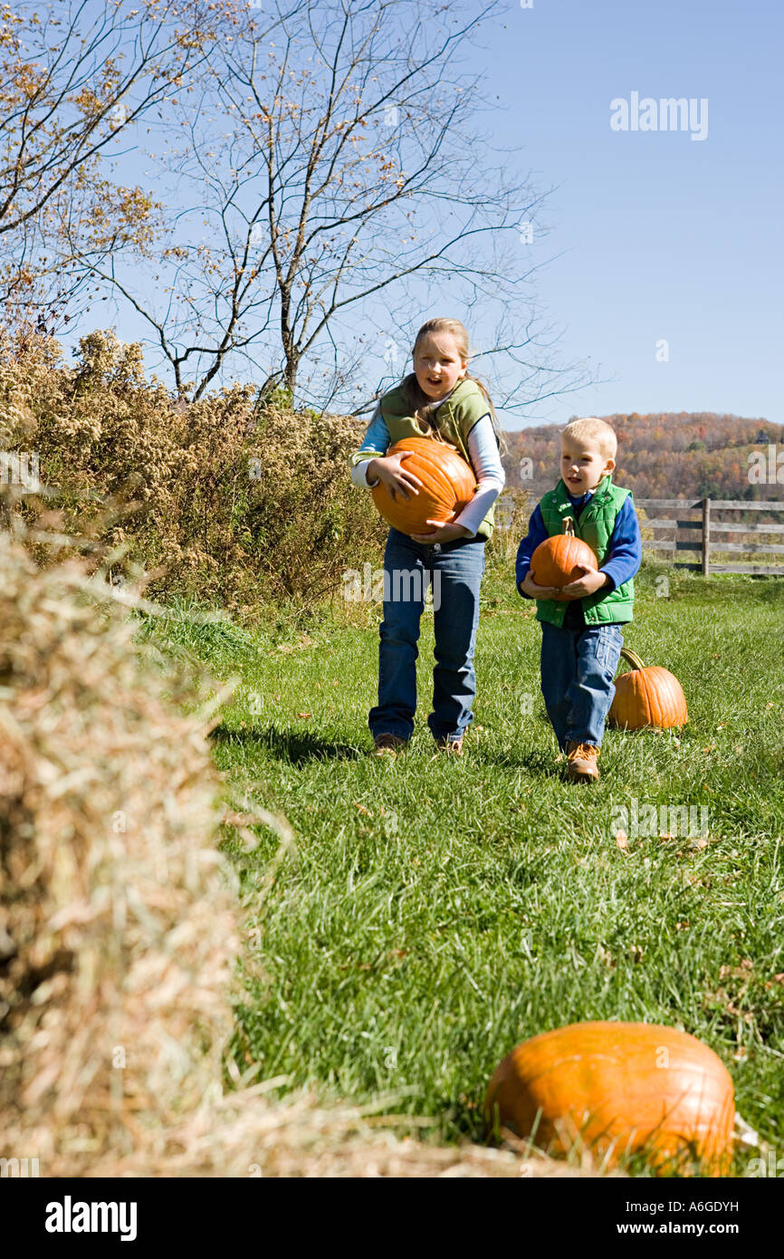 Boy and girl carrying pumpkins Stock Photo - Alamy
