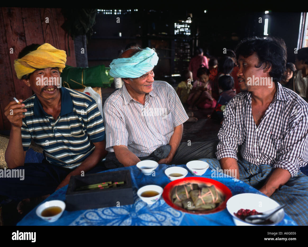 Myanmar Shan State Kalaw area 3 men seating at lower table in a hut ...