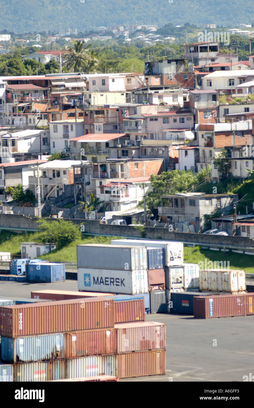 Cars and containers at the docks at Barbados with slums' right behind ...