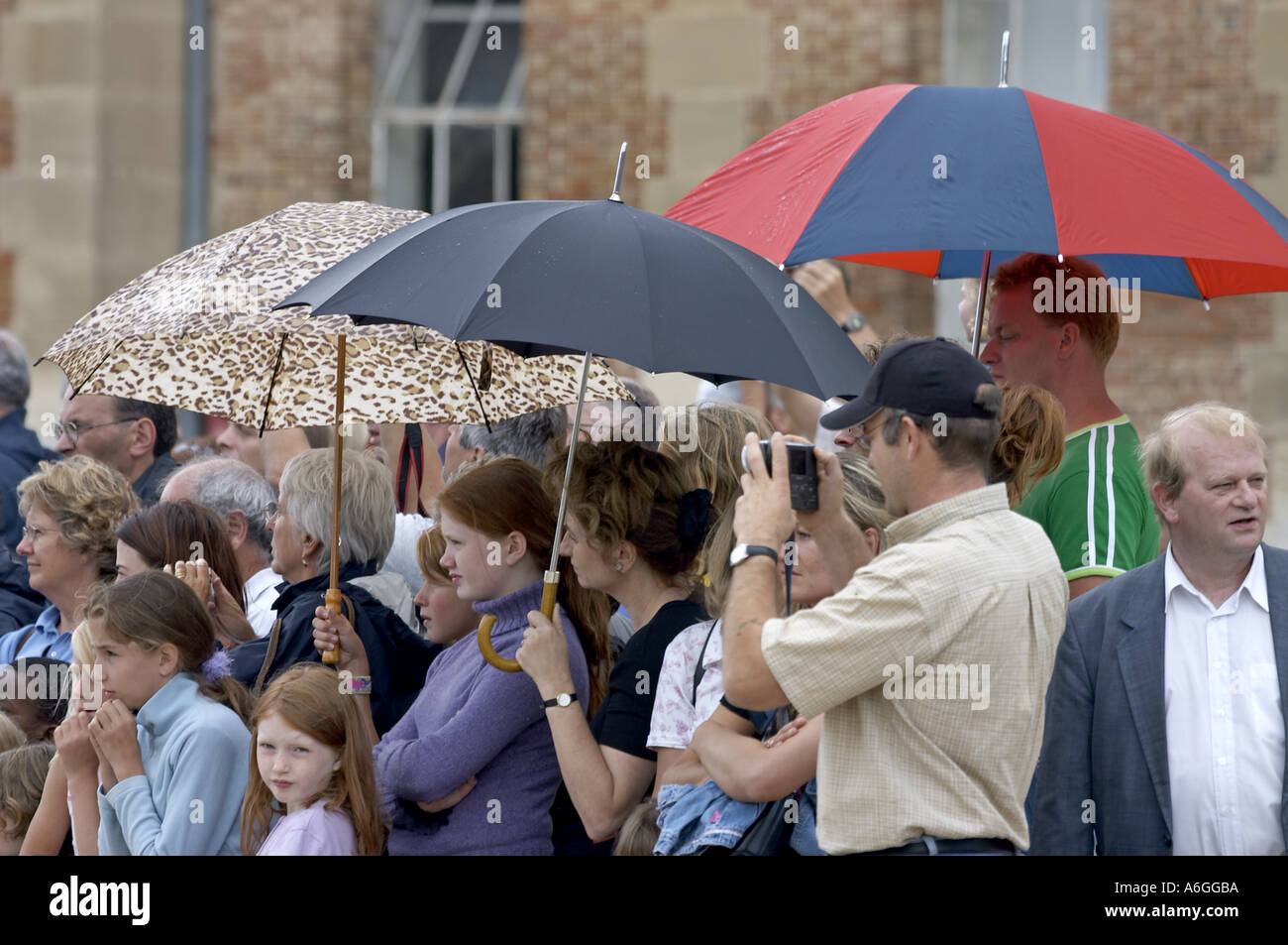 Spectators with umbrellas at equestrian demonstration Le Haras du Pin ...