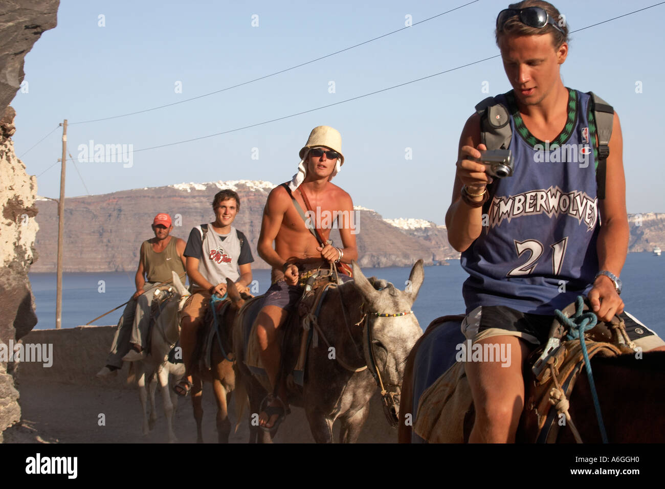 People riding mules or donkeys up the caldera cliff path to Oia or Ia ...