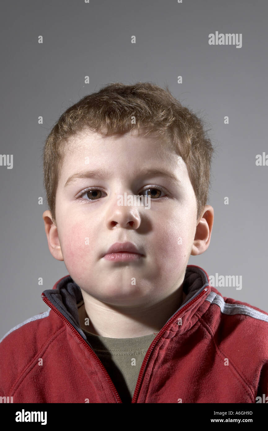 Young boy looking implacable and uninterested Stock Photo - Alamy
