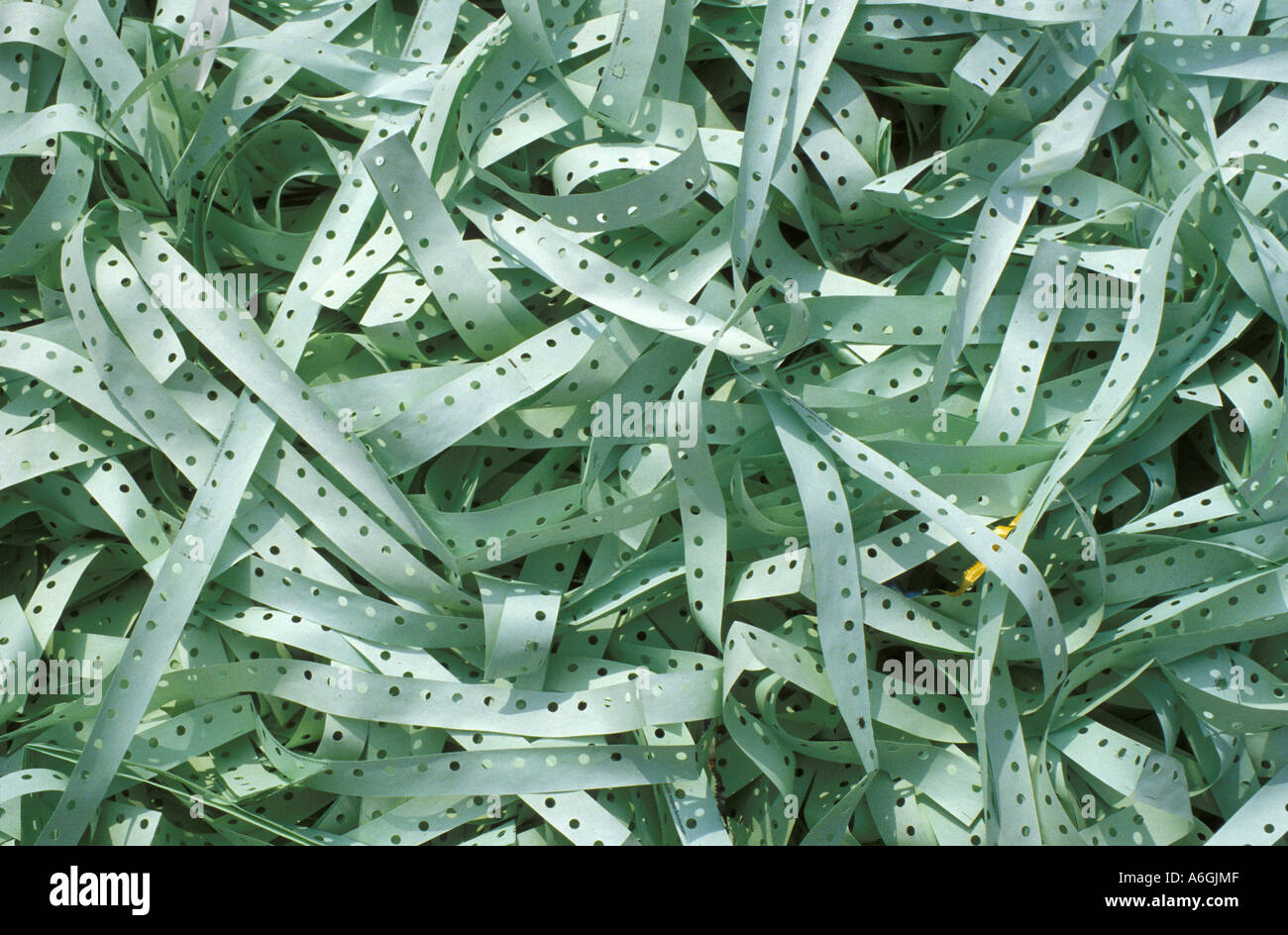Disheveled clump of green, perforated waste paper stripes (edges of ...