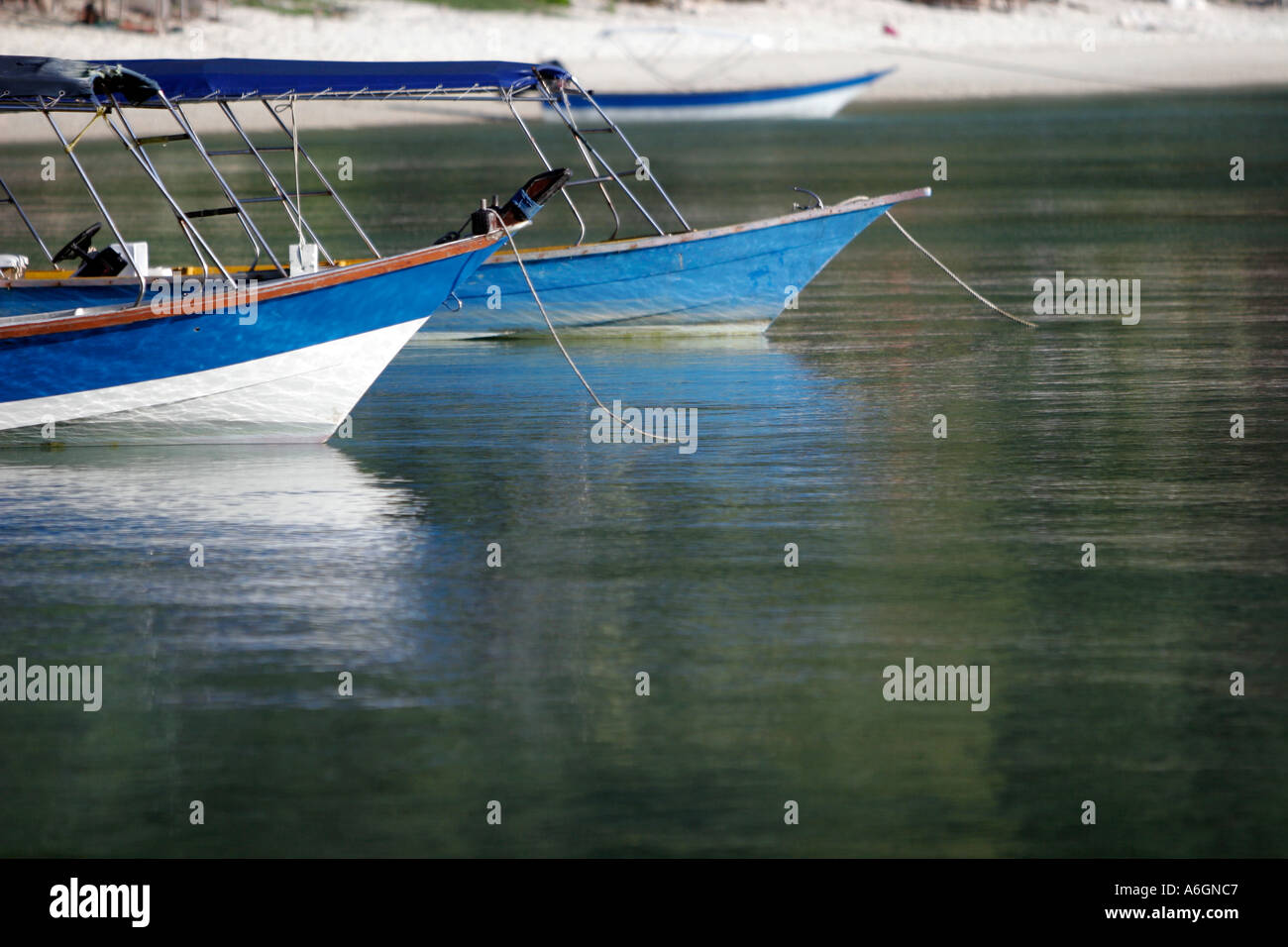 Bows of small boats anchored in flat water Perhentian Kecil Malaysia ...